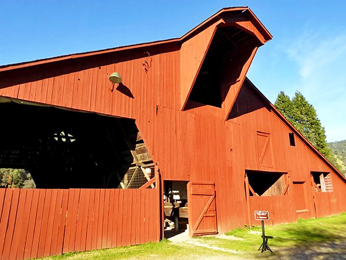 This vintage red barn near the bridge completes the historical landscape, standing as another testament to pioneer craftsmanship and determination.
