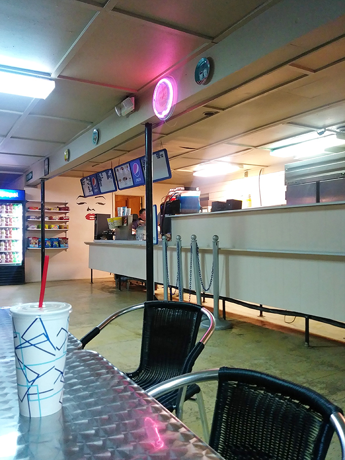 The refreshment area&mdash;where movie memories are made one concession at a time. The neon glow beckons with promises of buttery popcorn.