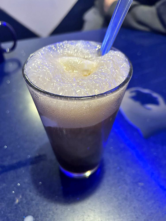 Root beer float with that perfect foam-to-liquid ratio&mdash;childhood nostalgia served in a glass, with a side of blue ambiance.