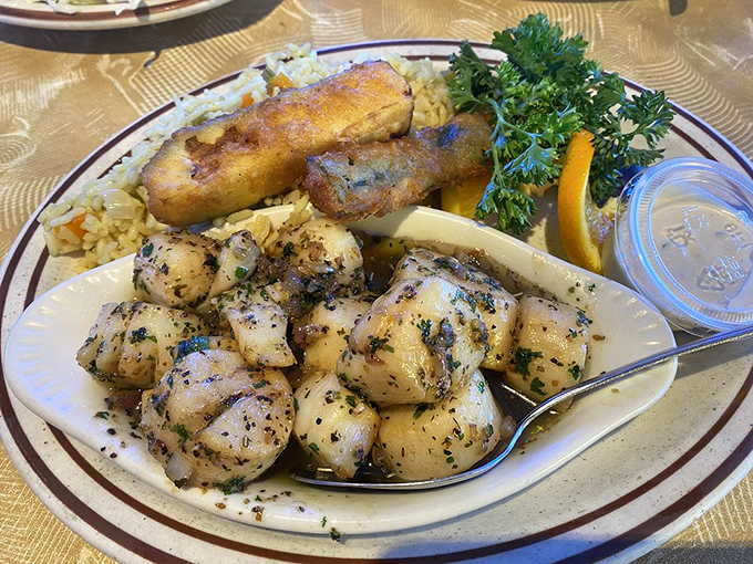 These garlic scallops are perfectly caramelized treasures from the deep, served alongside fish that's clearly living its best life.