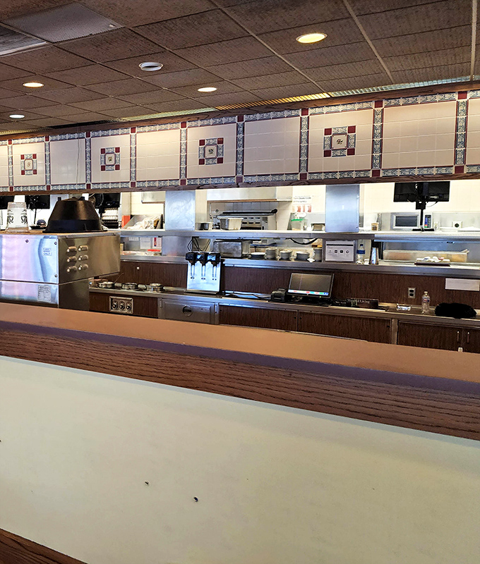 The service counter offers a glimpse into the kitchen's rhythm, where orders are called and comfort food dreams become delicious reality.