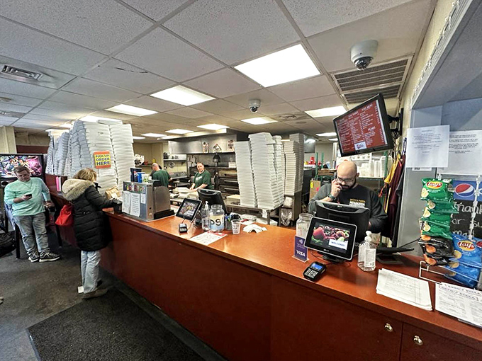 Where pizza dreams become reality&mdash;the counter where orders are placed and anticipation begins. Those stacked pizza boxes stand ready for their moment of glory.