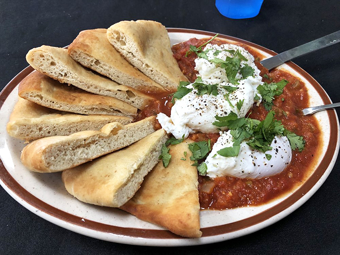 Poached eggs floating on a sea of spiced tomato sauce with fresh-baked bread standing by for dipping duty. Breakfast elevated to art form.