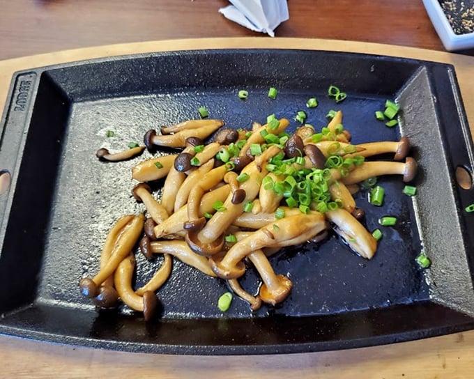 Shimeji mushrooms sizzling on a hot plate &ndash; nature's little umami bombs exploding with earthy goodness.
