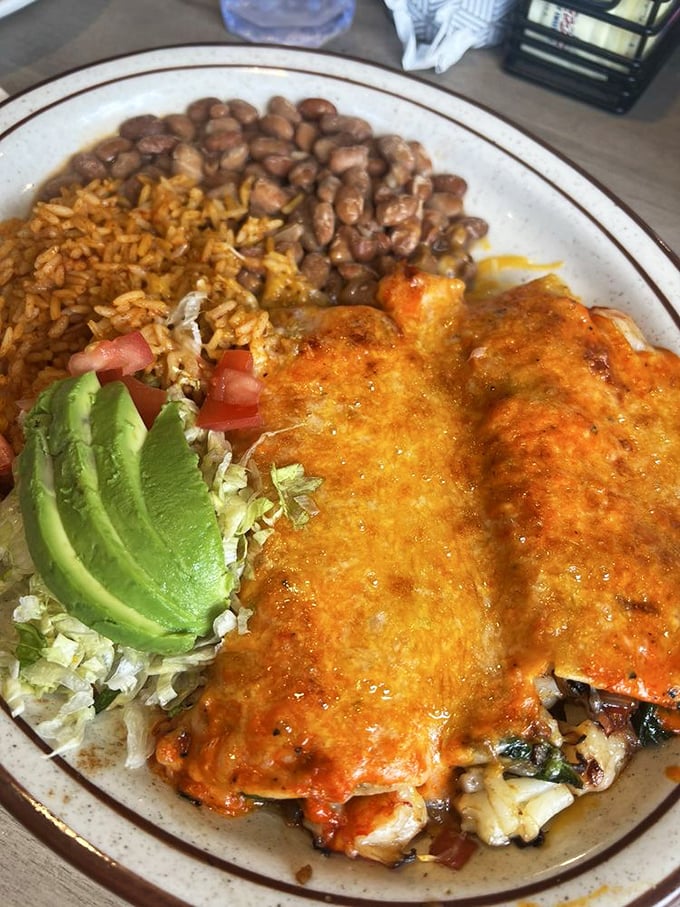 Rice, beans, and cheese-smothered enchiladas with a perfect slice of avocado&mdash;comfort food that speaks the universal language of "delicious." 