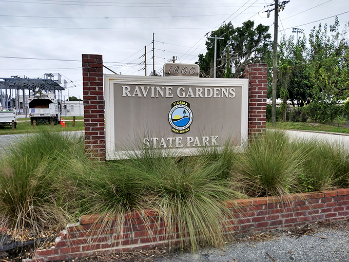The unassuming entrance sign belies the natural wonders waiting beyond, like finding out your quiet neighbor is secretly a world-class chef.