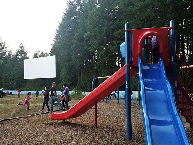 Colorful slides and climbing structures stand sentinel beside the massive screen, a reminder that drive-ins understand family entertainment better than anyone.