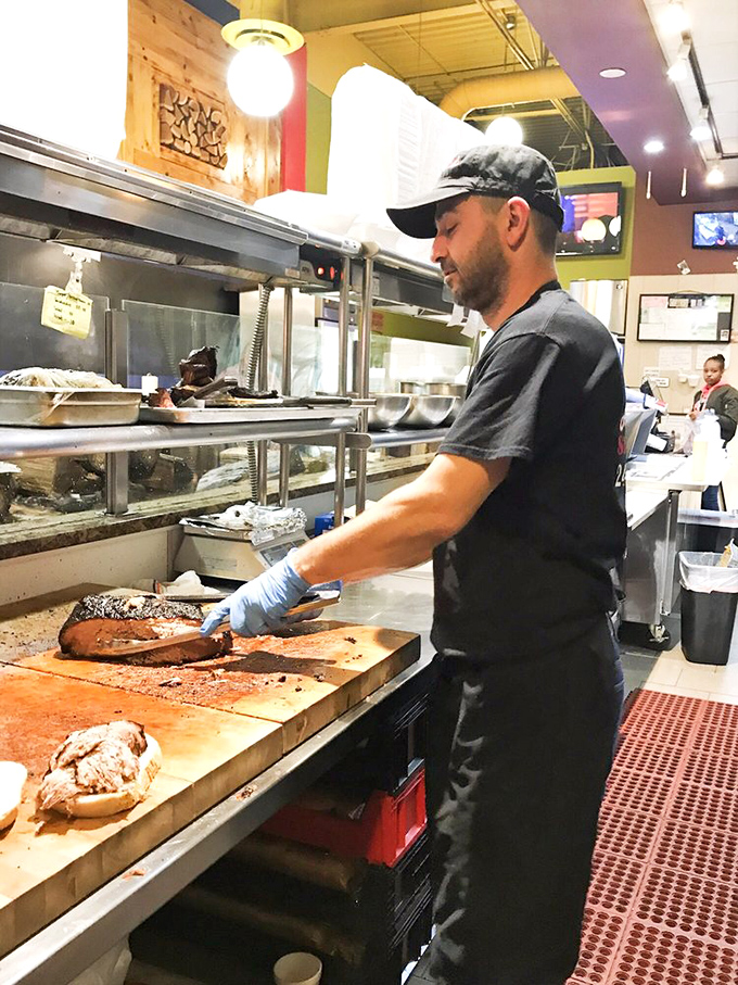 The maestro at work, slicing brisket with surgical precision. Behind every great barbecue is someone who respects the meat.