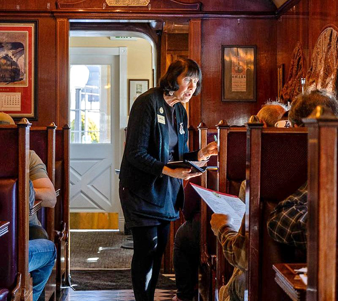 The staff navigates the narrow railcar with the precision of seasoned train conductors, delivering plates of comfort food with practiced efficiency.