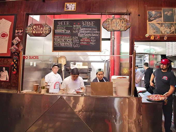 Behind the counter, the pizza ballet unfolds &ndash; practiced hands moving with the confidence that comes only from thousands of pies.