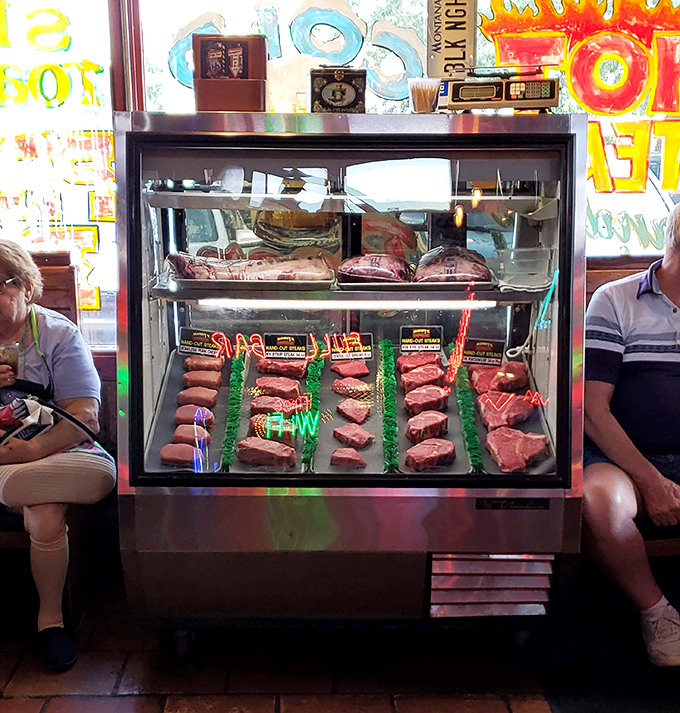 The meat display case—where steaks wait like contestants in a beauty pageant, each one hoping to be your dinner selection tonight.