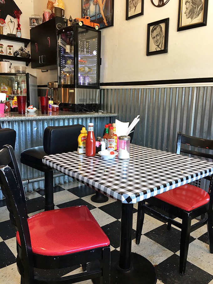 Black and white checkered floors meet black and red chairs. The classic diner aesthetic is alive and well at this cozy corner table.