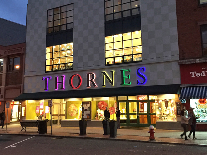 Thornes Marketplace glows like a jewelry box at dusk, each window a treasure chest of possibilities. Shopping as theater.