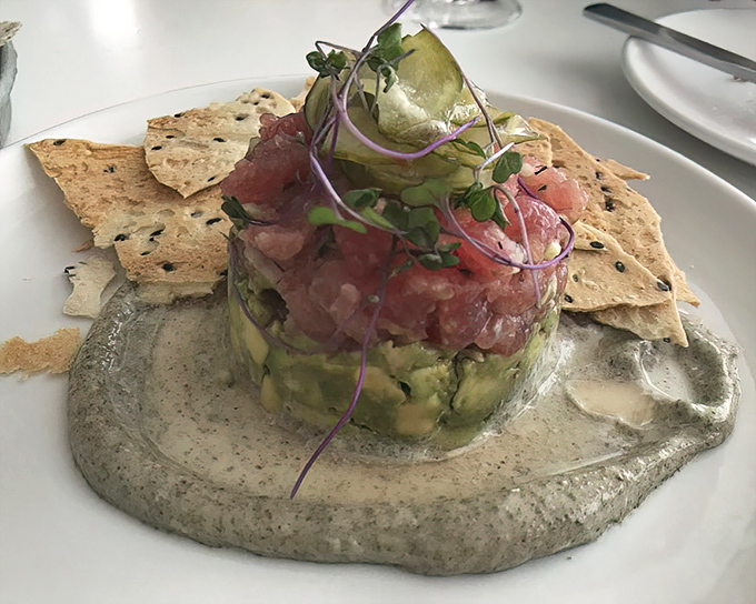 Tuna tartare that's dressed better than most people at fashion week. This elegant tower of flavor sits on a throne of creamy sauce.