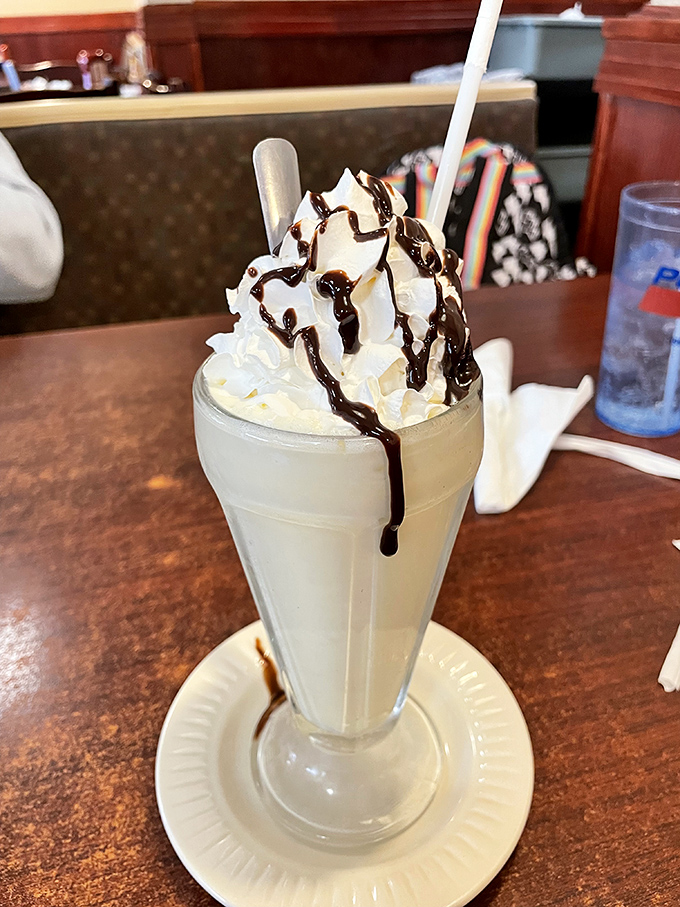 Not just a milkshake, but a towering monument to dairy devotion, where whipped cream and chocolate drizzle create a symphony in a glass.