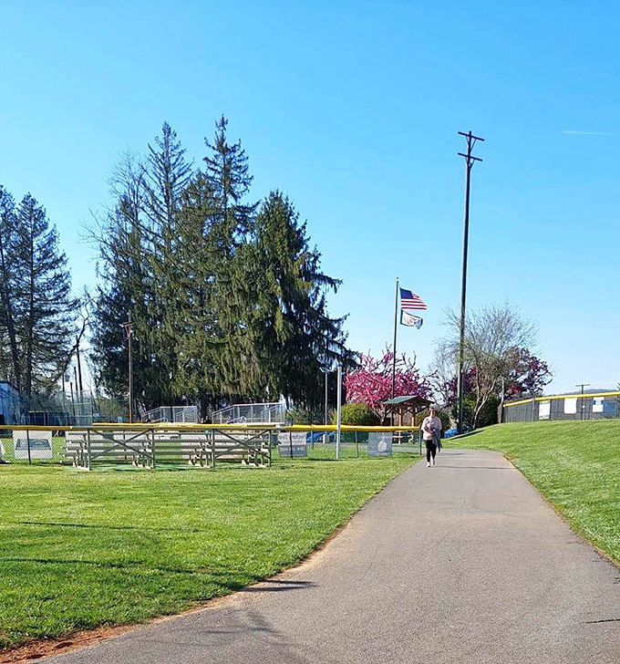 Morning walks along tree-lined paths offer moments of quiet reflection, with America's flag standing sentinel against the clear blue sky.