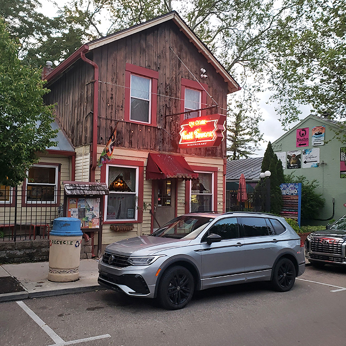 Ye Olde Trail Tavern's rustic wooden facade and neon sign beckon hungry travelers. This cozy spot looks like it could tell stories spanning several centuries.
