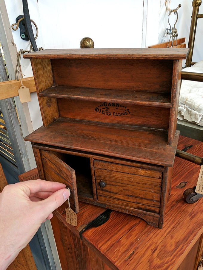 A miniature Hoosier cabinet that probably held tiny flour for very small biscuits in a dollhouse kitchen.