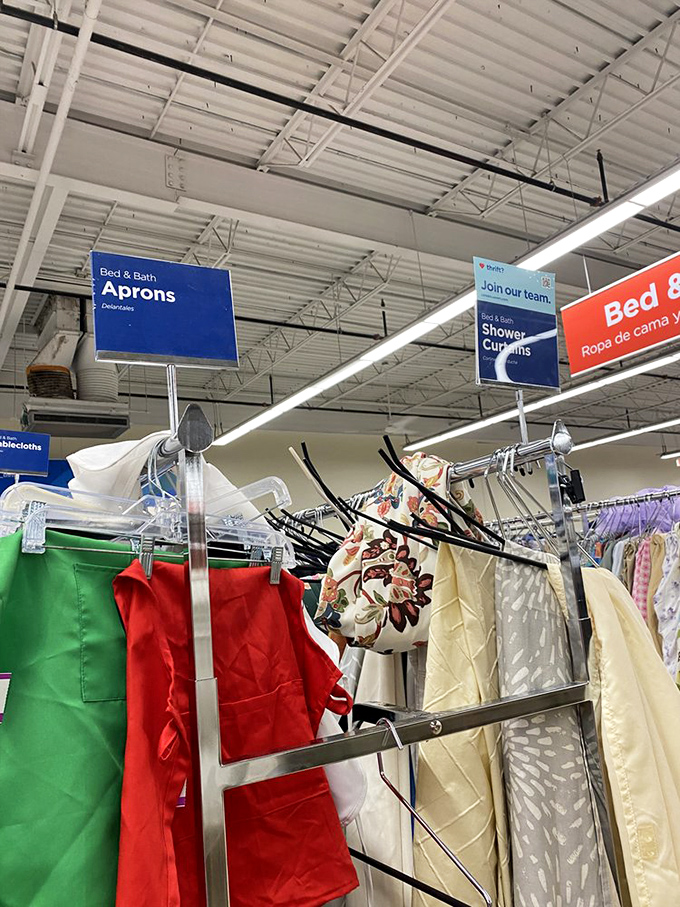 The home goods section, where vintage aprons and shower curtains await their second act in your kitchen or bathroom renovation story.