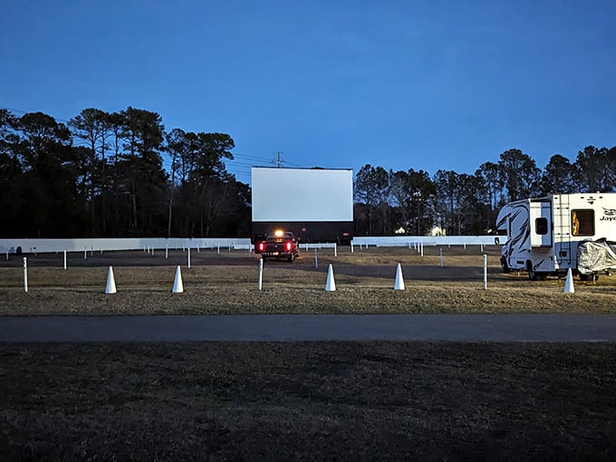 As twilight fades, headlights guide latecomers to their spots. The anticipation builds as the projection booth readies the first feature.