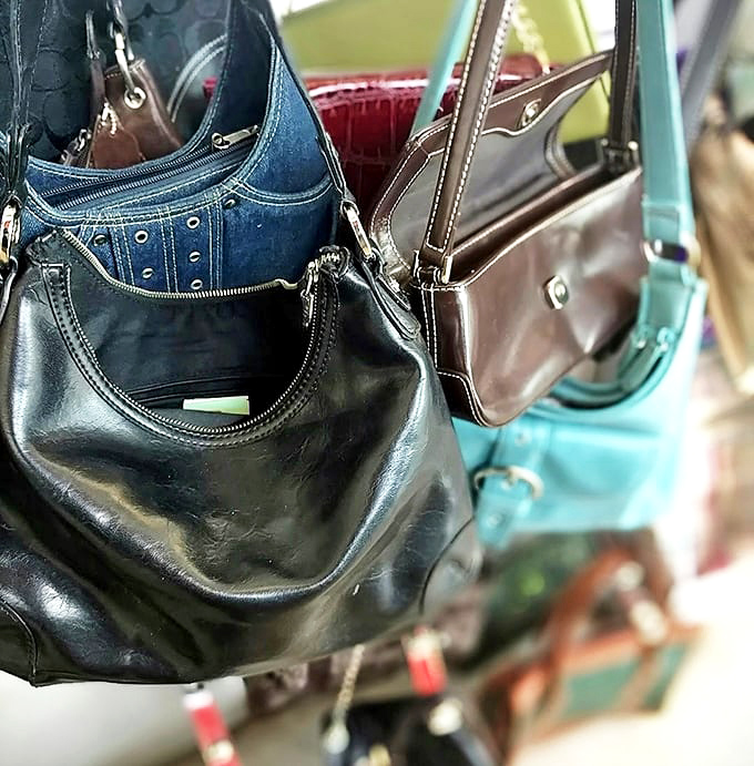 Handbags hanging like ripe fruit, ready to be plucked by savvy shoppers. That navy leather number has decades of stylish service left. 