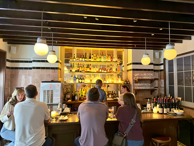 A well-stocked bar bathed in golden light&mdash;where strangers become friends and ordinary evenings transform into memorable nights.