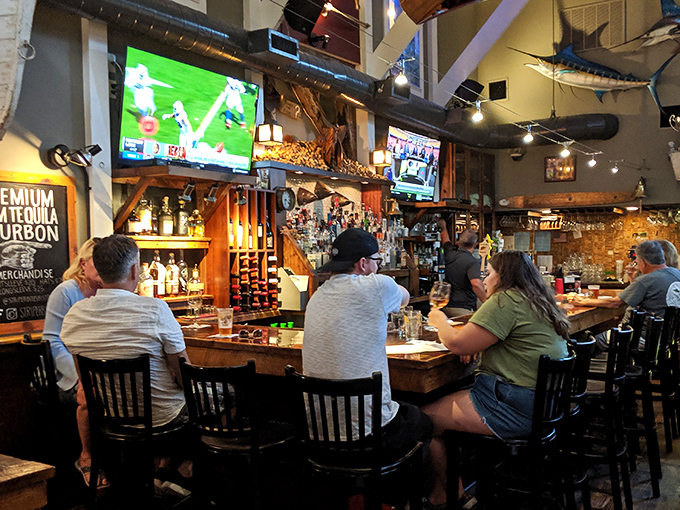 The bar at Striper Bites&mdash;where strangers become friends and friends become regulars. Those bourbon bottles aren't just decoration&mdash;they're liquid possibilities.
