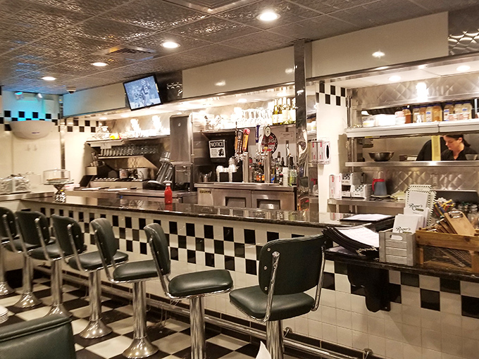 The counter area showcases the heart of diner operations &ndash; where orders are called, coffee is poured, and the magic happens behind checkered tiles.