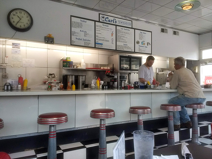 The counter where regulars perch on red stools, watching their breakfast materialize before their very eyes.