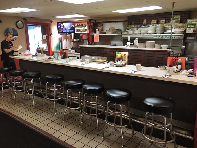 The counter where regulars earn their status one cup of coffee at a time. Those stools have supported more local gossip than the town newspaper.