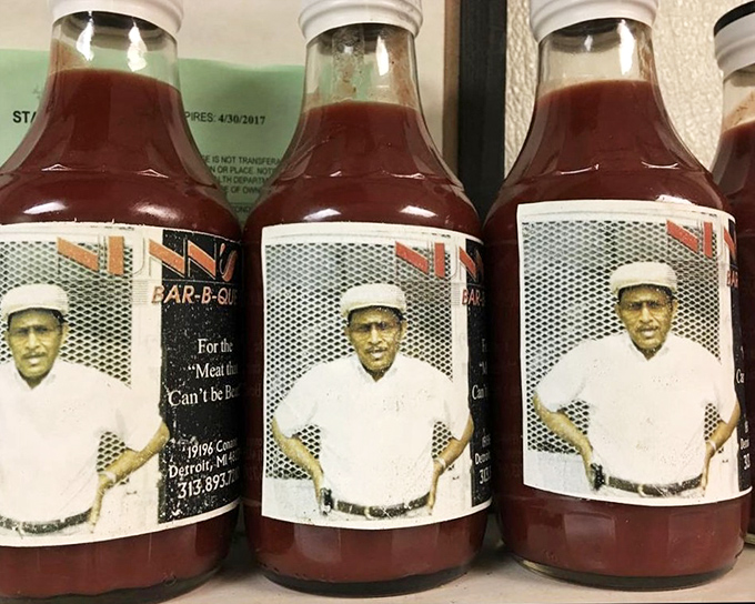 Bottles of house sauce standing like sentinels of flavor. The secret weapon that transforms good barbecue into unforgettable barbecue.