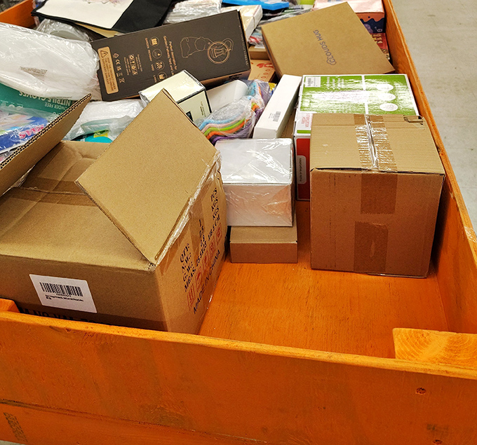 Each cardboard box contains potential joy, like a game show where every contestant wins something they actually need.