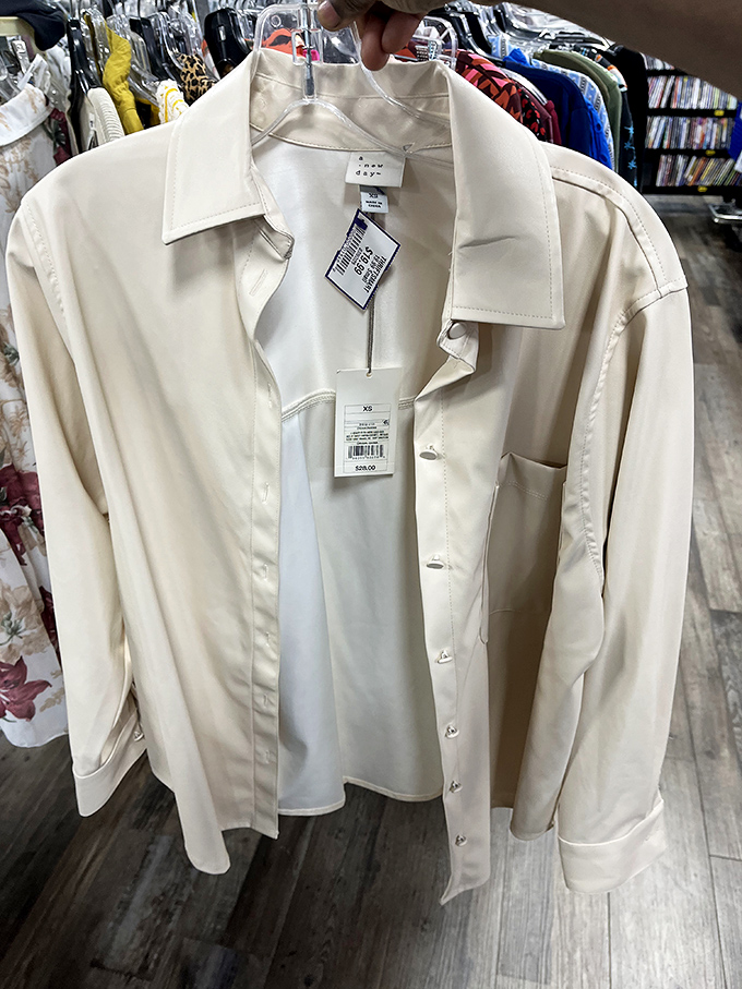 The holy grail of thrift finds: a pristine cream button-down with tags still attached. Someone's retail regret becomes your wardrobe win.
