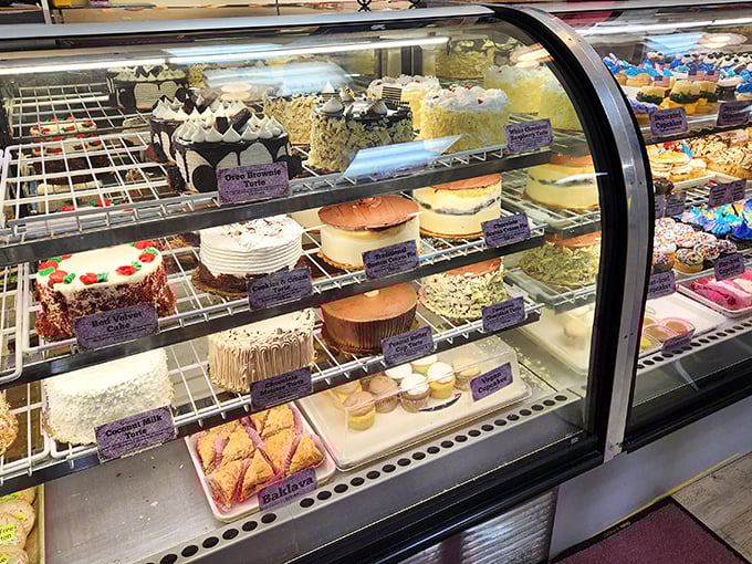 A display case that's essentially a museum of cake artistry, showcasing creations that deserve their own exhibition at the Louvre of Desserts.