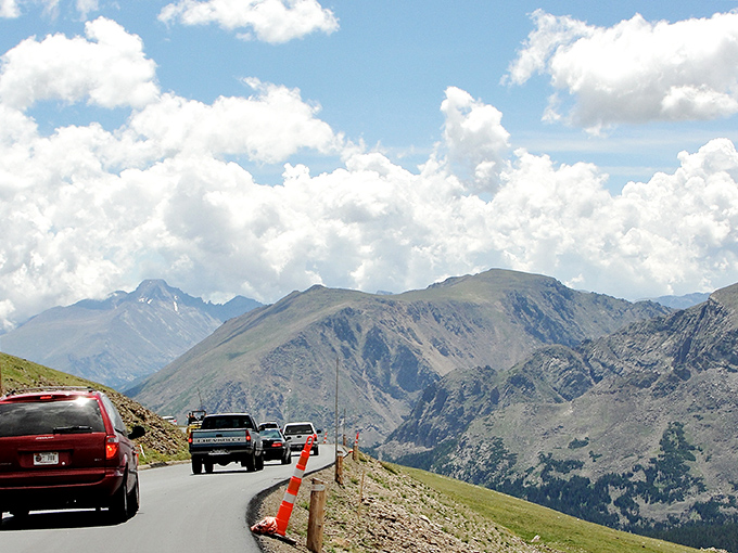 Vehicles hug the edge of infinity, where guardrails separate Sunday drivers from geological drama millions of years in the making.
