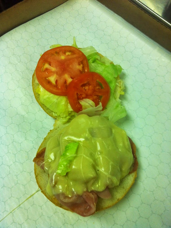 The assembly line of sandwich perfection. That lettuce and tomato aren't just toppings—they're the finishing touches on a masterpiece.
