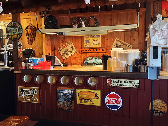 The counter where barbecue dreams come true, adorned with vintage signs that aren't manufactured nostalgia&mdash;they're badges of honor earned through years of smoke.