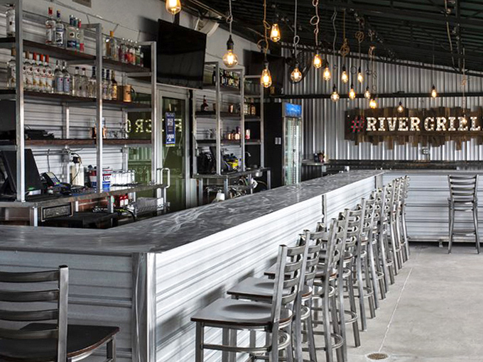 The bar gleams with promise, Edison bulbs casting a warm glow over bottles that stand ready like soldiers awaiting your order.