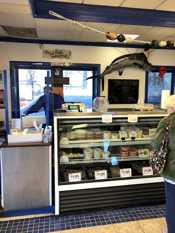 Behind this counter, seafood magic happens daily. That mounted fish? He's just supervising quality control from his place of honor.