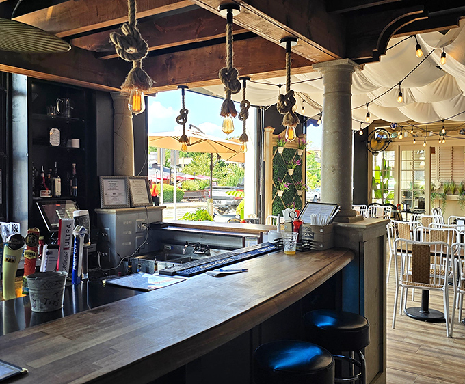 Edison bulbs dangling from rope fixtures illuminate a bar counter where cocktail magic happens daily, no wand required.
