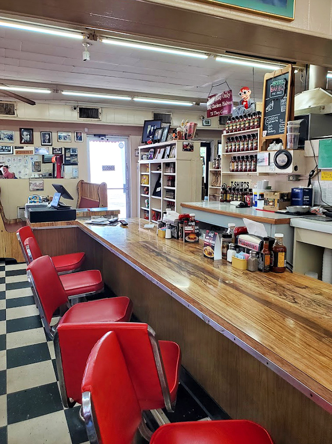 The counter where BBQ dreams come true. Those red stools have supported generations of diners waiting for their moment of smoked meat nirvana.