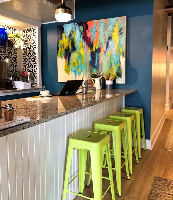 Vibrant blue walls and lime green stools invite you to pull up a seat and enjoy this bright, cozy space.