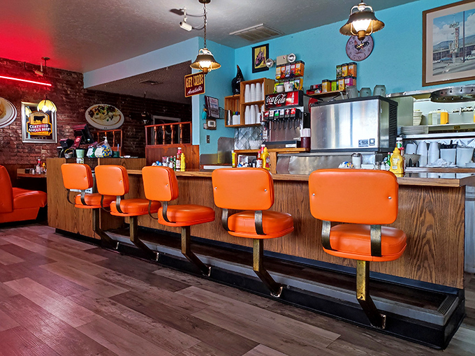 Counter seating where regulars have worn grooves into those swiveling orange thrones. Prime real estate for coffee refill efficiency.