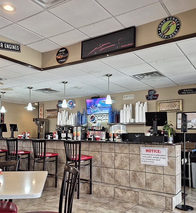 Counter seating where coffee refills appear like magic and the soda fountain hums the background music of American diner culture.