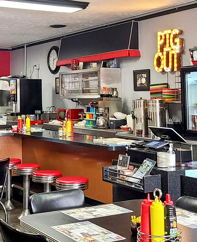 Counter seating: where solo diners become regulars and the "PIG OUT" sign serves as both decoration and gentle suggestion for how to approach your meal.