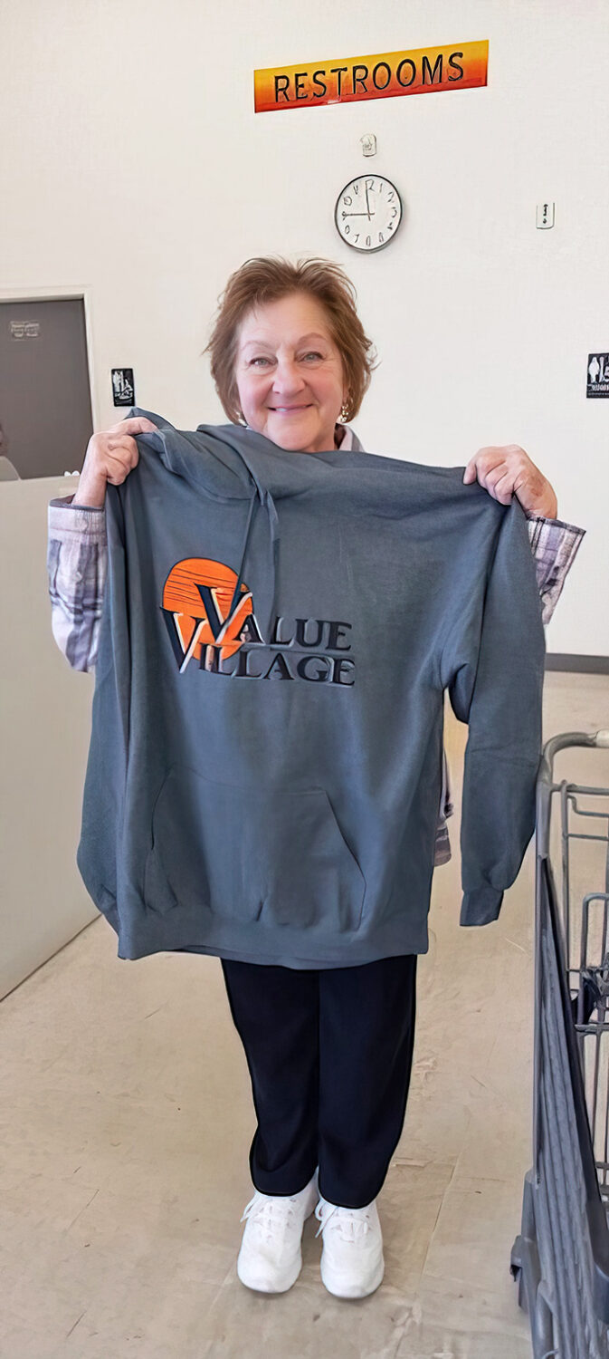 "Look what I found!" A delighted shopper displays her Value Village branded sweatshirt score.
