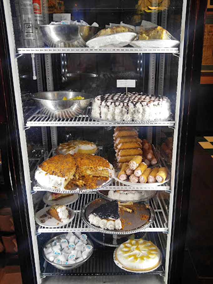 The dessert case that stops conversations mid-sentence. Each shelf offers a different path to sweet happiness, making decisions deliciously difficult.