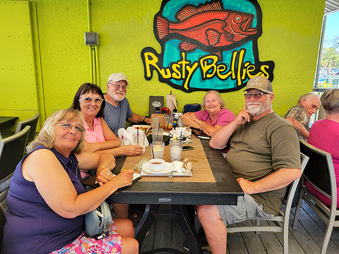 Happy diners beneath the colorful Rusty Bellies logo &ndash; creating memories that will last longer than their seafood-induced food coma.