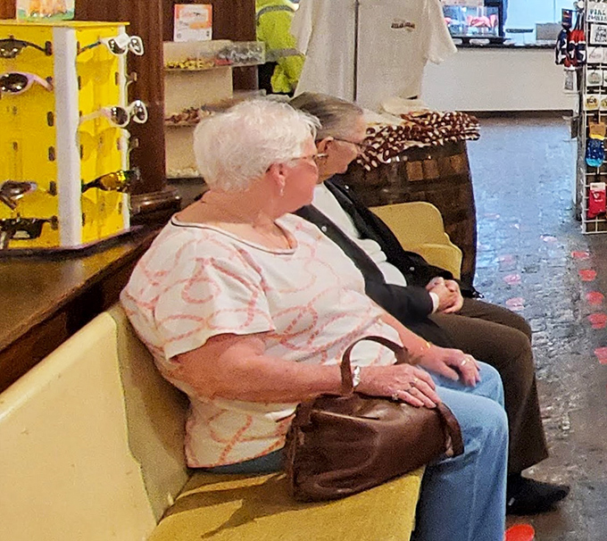 Two patrons rest between courses, perhaps contemplating their next buffet strategy or simply enjoying the timeless ritual of a country store visit.