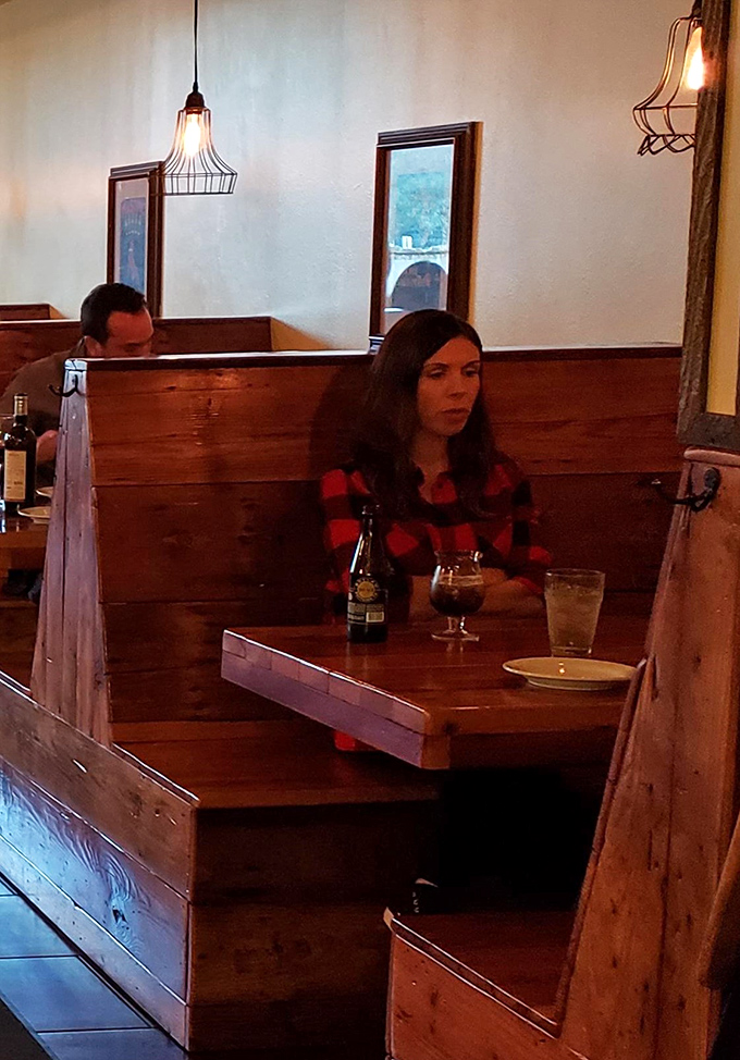 Cozy wooden booths and pendant lighting create the perfect atmosphere for date night or celebrating surviving another Monday.